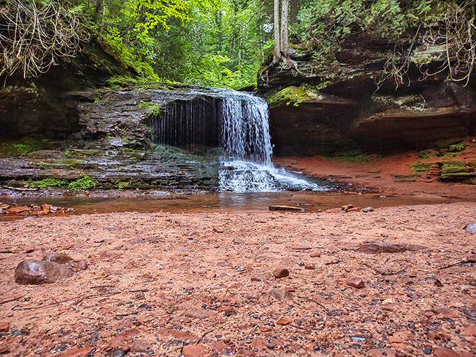The reddish rock and clear pool at Morgan Falls look like something from a fantasy movie where adventures definitely happen.