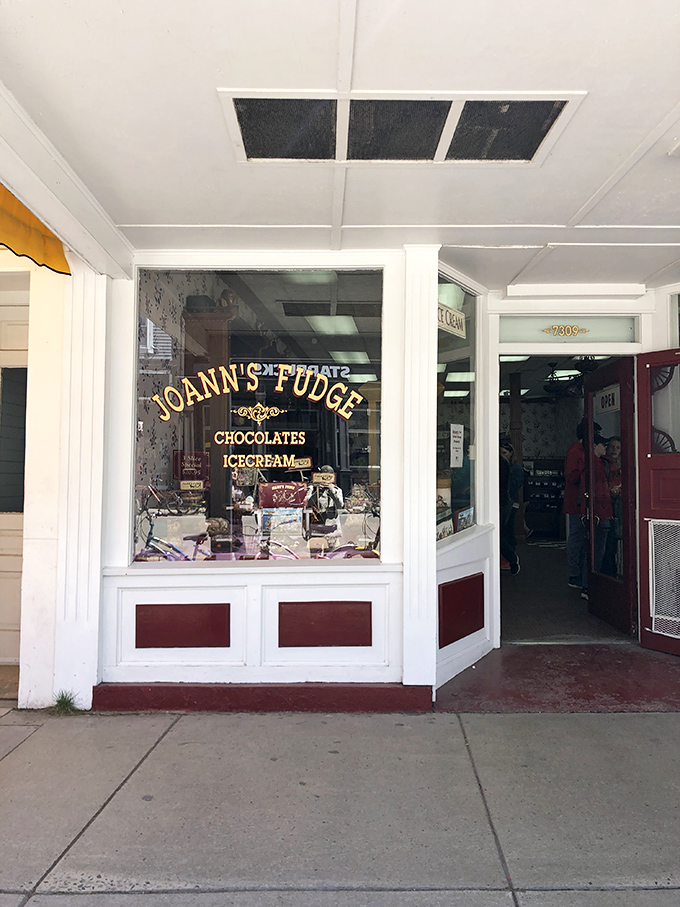 Step into a time machine disguised as a fudge shop! Joann's Fudge beckons with its classic white facade and red trim, promising sweet nostalgia inside.