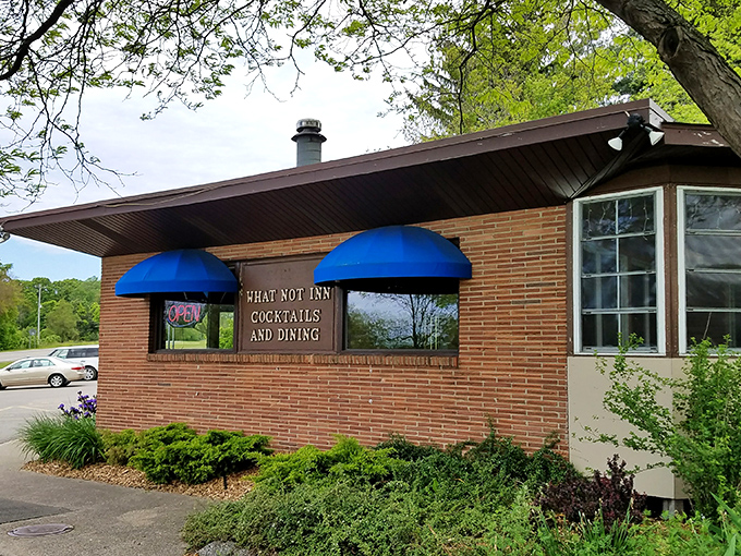 Blue awnings and brick walls: The What-Not Inn beckons like a cozy oasis in the Michigan countryside. Come for the cocktails, stay for the charm!