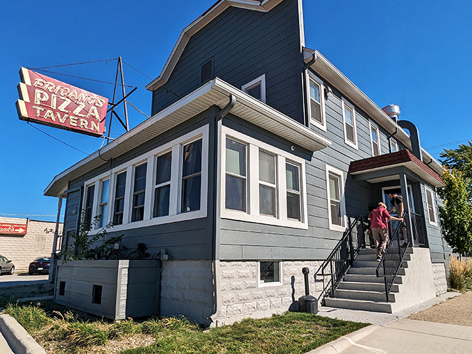 A beacon of pizza perfection! This unassuming gray house with its iconic red sign has been luring in hungry patrons for decades.
