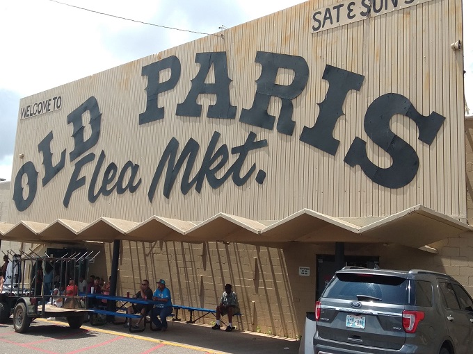 Welcome to the treasure hunter's paradise! Old Paris Flea Market beckons with its retro sign, promising a labyrinth of curiosities and bargains inside.