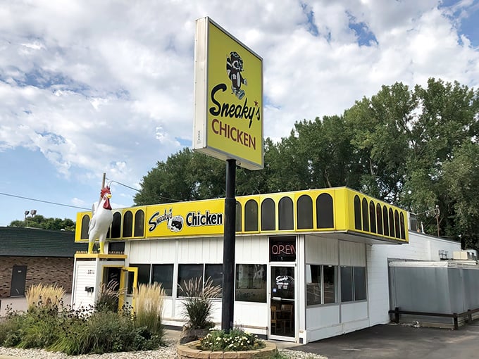 Behold, the golden beacon of poultry perfection! Sneaky's Chicken stands proud, its vibrant yellow exterior a siren call to hungry souls seeking crispy comfort.