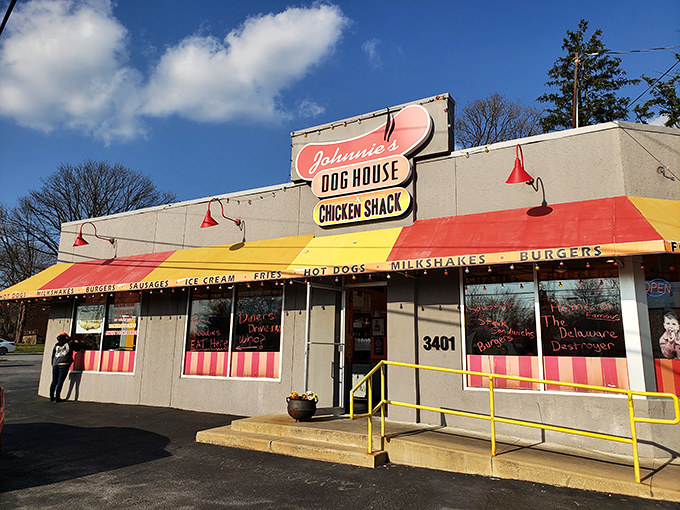 Welcome to flavor town! Johnnie's Dog House and Chicken Shack beckons with its cheerful awning and promise of comfort food that'll make your taste buds do a happy dance.