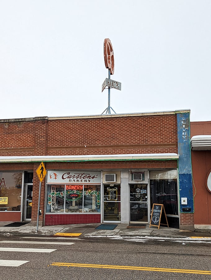 Welcome to carb heaven! This unassuming brick facade hides a treasure trove of baked delights, crowned by a giant pretzel sign that's basically a bat-signal for pastry lovers.