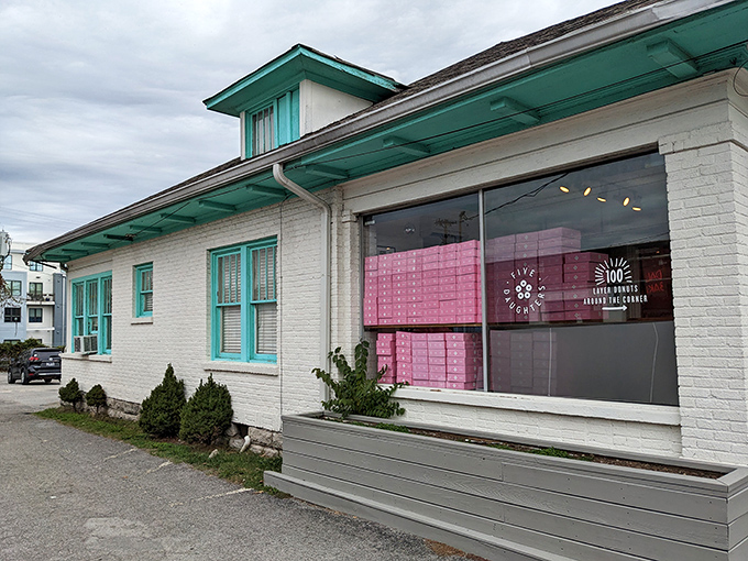 A sugar-coated wonderland awaits! Five Daughters Bakery's charming exterior promises sweet delights, with its teal trim and inviting patio beckoning donut lovers like a siren's call