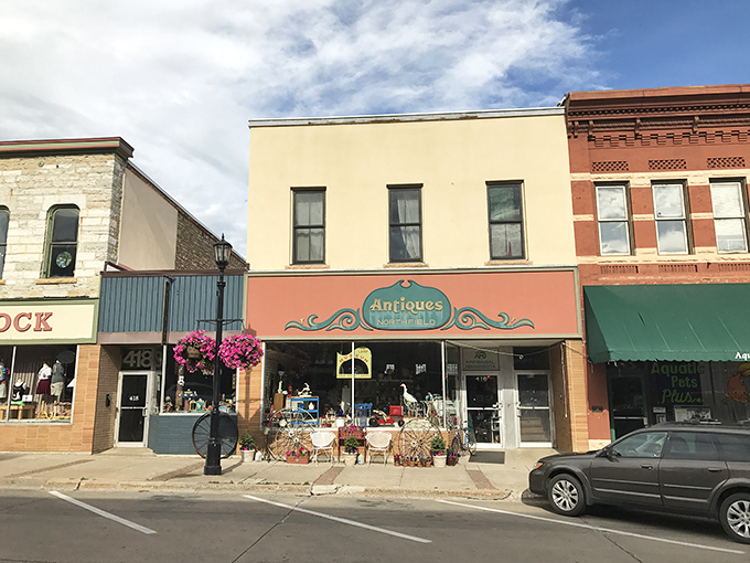 Step into a time machine disguised as a storefront! Antiques of Northfield's whimsical window display is like your grandma's attic, but curated by a magical decorator.