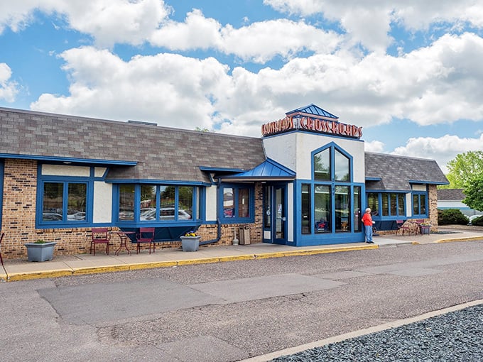 A beacon of deliciousness! Crossroads Delicatessen stands proud, its blue-trimmed windows winking at hungry passersby like a culinary lighthouse guiding you to sandwich nirvana.