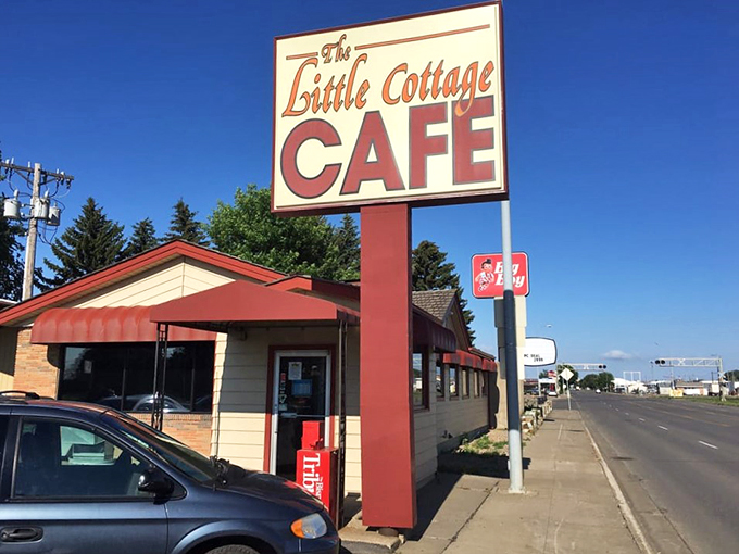 Welcome to flavor town! The Little Cottage Caf&eacute;'s sign promises big taste in a small package, like a culinary TARDIS waiting to be explored.
