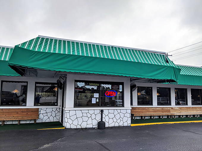A green-striped awning beckons like a breakfast lighthouse, guiding hungry souls to this unassuming pancake paradise. No frills, just thrills for your taste buds.