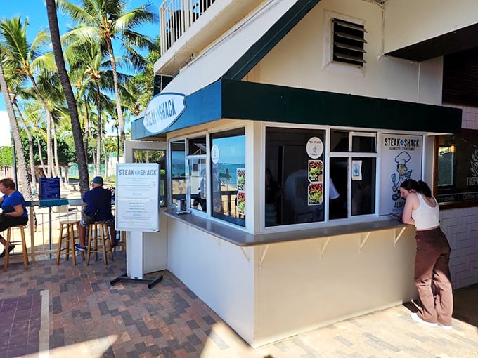 Surf's up, and so is your appetite! The Steak Shack's surfboard sign promises waves of flavor just steps from Waikiki Beach.