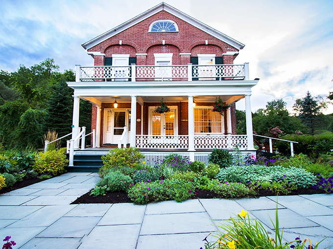 A storybook come to life! This charming red brick fa&ccedil;ade with its white-columned porch whispers tales of lazy summer evenings and hot cocoa by the fire.