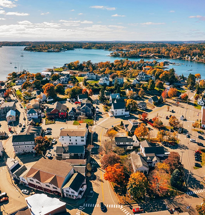 Autumn's paintbrush transforms Boothbay Harbor into a masterpiece. This aerial view showcases the town's picturesque charm, with colorful foliage framing the tranquil waters and quaint buildings.