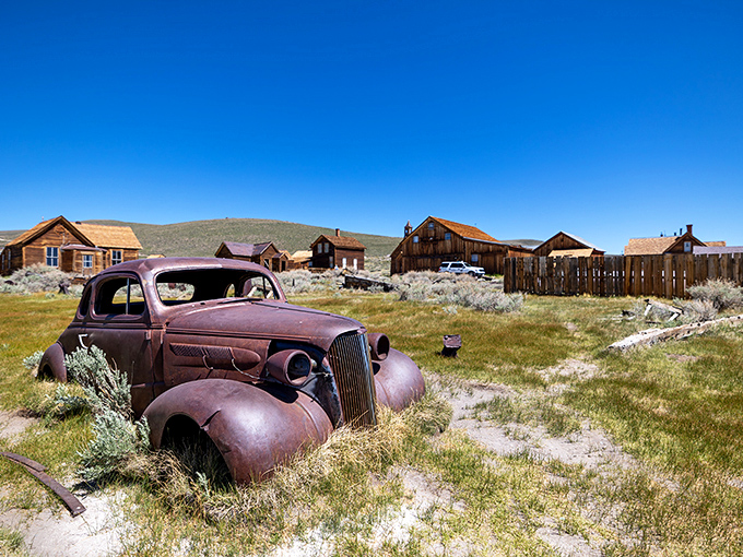
"Rust never sleeps, but this old jalopy sure does!" A weathered vintage car rests peacefully among wooden buildings, telling tales of Bodie's golden days.