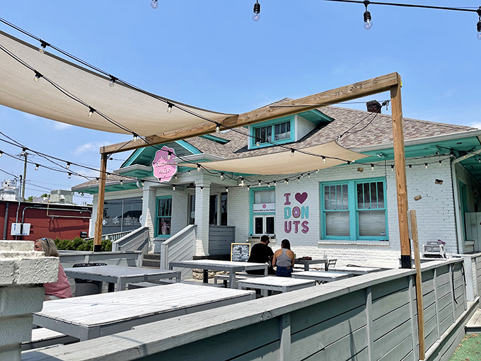 A sugar-coated wonderland awaits! Five Daughters Bakery's charming exterior promises sweet delights, with its teal trim and inviting patio beckoning donut lovers like a siren's call.