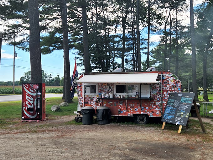 Welcome to BBQ paradise! This colorful food truck, nestled among towering pines, is where smoke signals spell out "delicious."