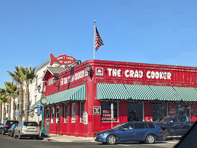A crimson beacon of seafood delight! The Crab Cooker's exterior is as bold as its flavors, with a cheeky sign that dares you not to look up.