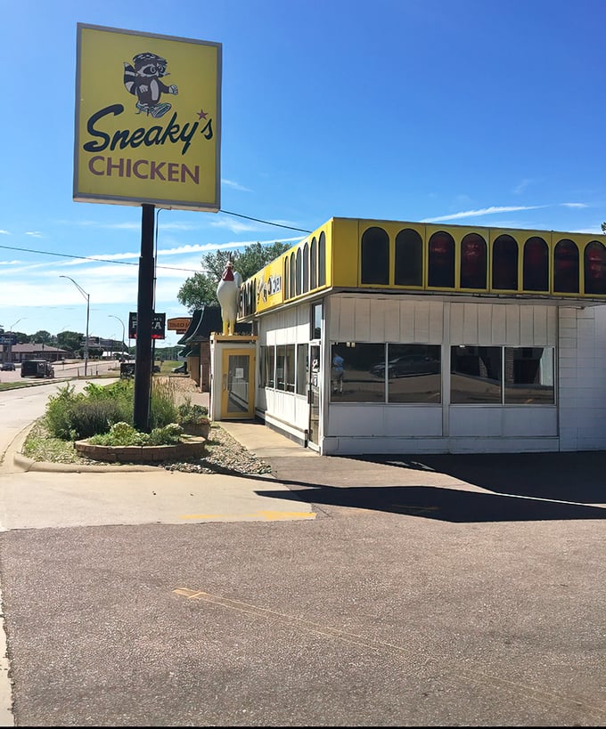 Behold, the golden beacon of poultry perfection! Sneaky's Chicken stands proud, its vibrant yellow exterior a siren call to hungry souls seeking crispy comfort.
