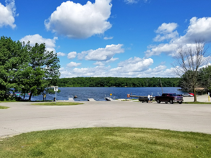 Nature's canvas unfolds: A serene lake view that would make Bob Ross reach for his paintbrush. Fluffy clouds, mirror-like water, and trees galore &ndash; it's like a real-life screensaver!