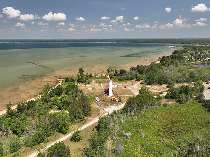 A bird's-eye view that'll make you feel like a seagull on vacation! Tawas Point's lighthouse stands sentinel over a patchwork of blue waters and green forests.