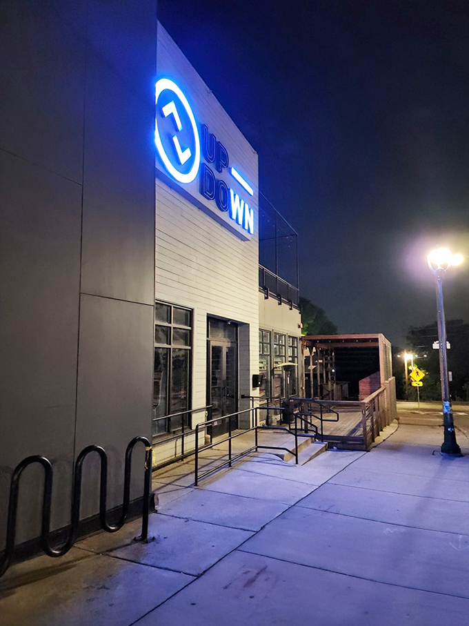 The neon blue sign of Up-Down glows invitingly against the night sky, beckoning visitors to this modern arcade bar.