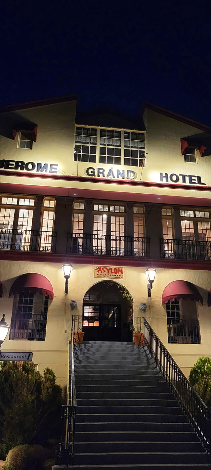 Perched like a watchful sentinel, the Jerome Grand Hotel stands tall, its yellow facade and red trim a beacon of mystery against the rugged Arizona landscape.