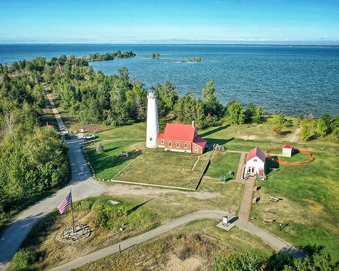 A bird's-eye view that'll make you feel like a seagull on vacation! Tawas Point's lighthouse stands sentinel over a patchwork of blue waters and green forests.