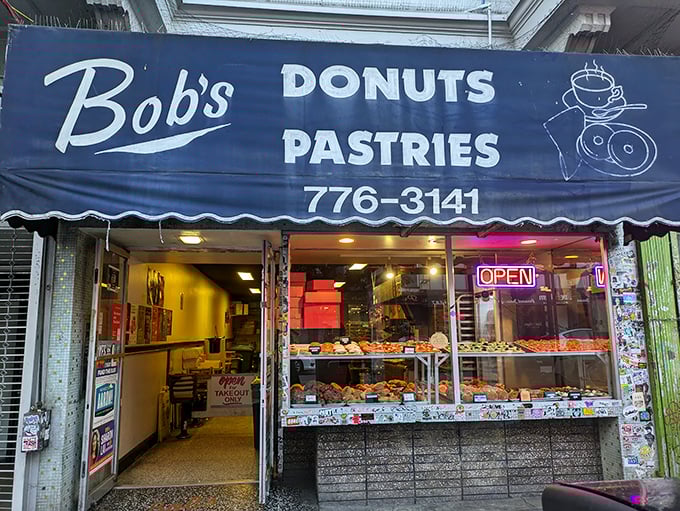 Welcome to donut paradise! Bob's blue awning beckons like a siren song, promising sweet delights 24/7. Resistance is futile, my friends.
