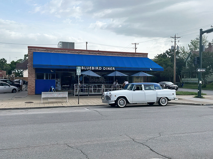 A blue beacon of breakfast bliss! The Bluebird Diner's cheery exterior promises comfort food that'll make your taste buds sing like Julie Andrews on a mountaintop.