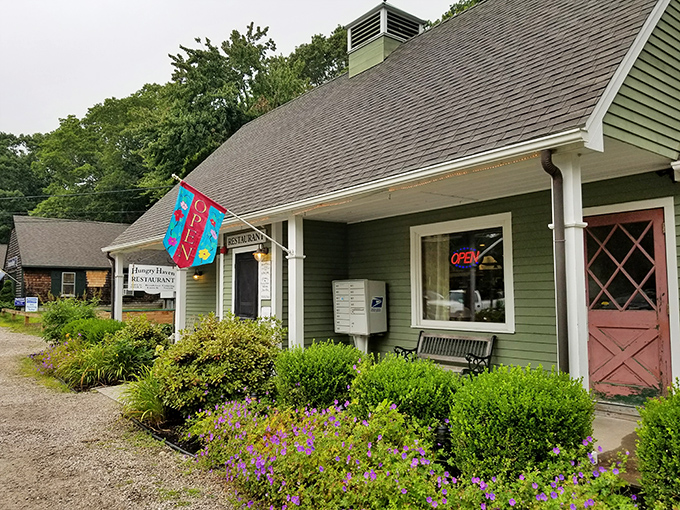 A cozy green haven beckons! The Hungry Haven's exterior is like a warm hug from your favorite aunt, complete with charming flower beds and a welcoming bench.