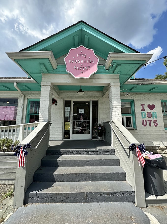 A sugar-coated wonderland awaits! Five Daughters Bakery's charming exterior promises sweet delights, with its teal trim and inviting patio beckoning donut lovers like a siren's call.