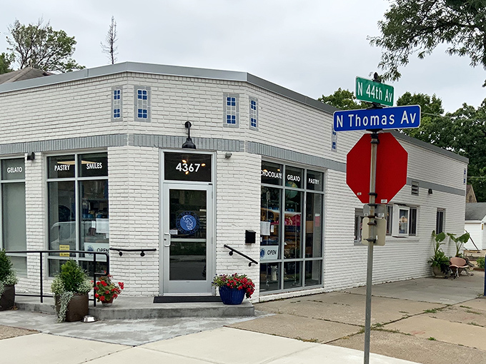 A sweet corner of Minneapolis! Dancing Bear Chocolate stands proudly at the intersection of 44th and Thomas, beckoning chocolate lovers with its charming brick facade and vibrant flower pots.