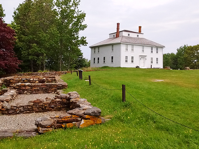 A white colonial house stands tall, its pristine facade a stark contrast to the ancient stone ruins at its feet. History's layers unfold before your eyes!