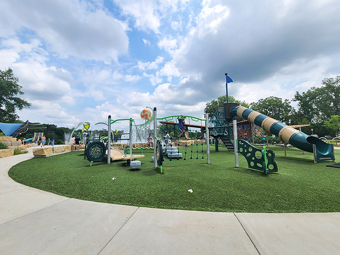 Fireman's Park Beach vibrant playground oasis beckons under a dramatic sky. Colorful slides, swings, and climbing structures promise endless fun for kids, while lush grass and winding paths invite exploration and adventure.