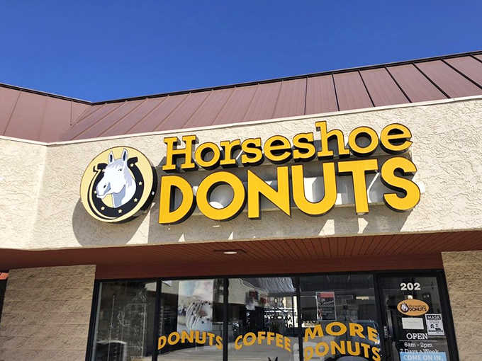 A horse of a different color! Horseshoe Donuts' cheerful yellow sign promises a sweet adventure in Monument, Colorado. Giddy up for glazed goodness!