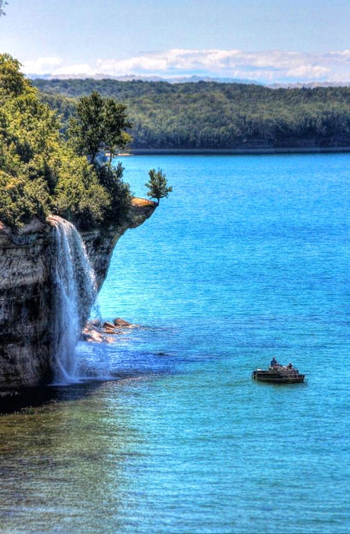 Honey, I shrunk the tourists! This tiny boat dwarfed by majestic cliffs and falls shows just how grand Mother Nature can be.