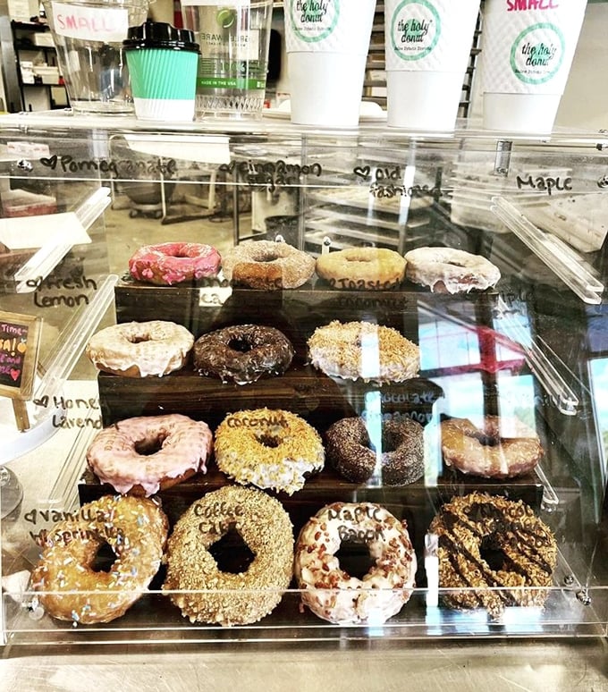 Donut decision paralysis is real, folks. This display case is like a museum of edible art &ndash; each piece more tempting than the last.