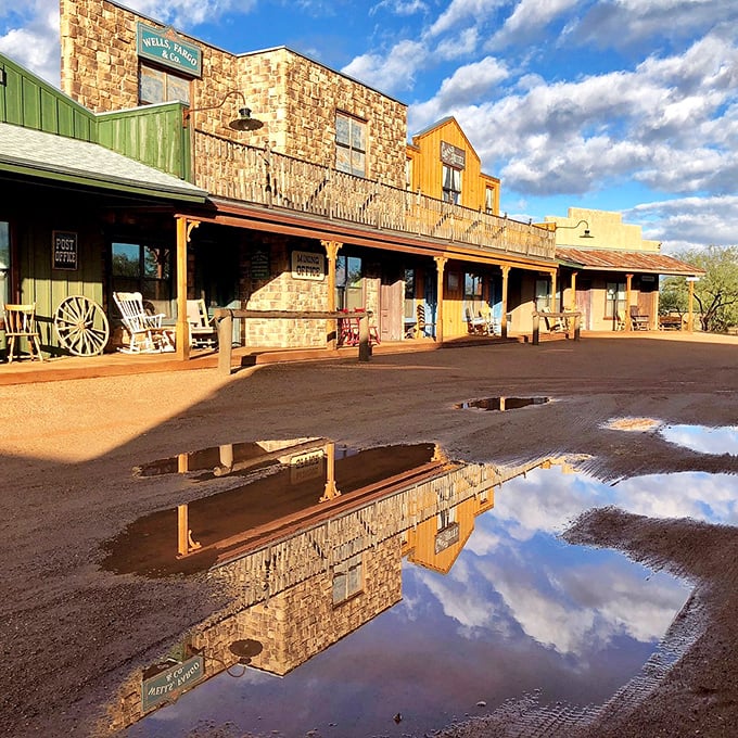 The rustic charm of Tombstone Monument Ranch reflects in rain puddles, creating mirror images of the Old West.