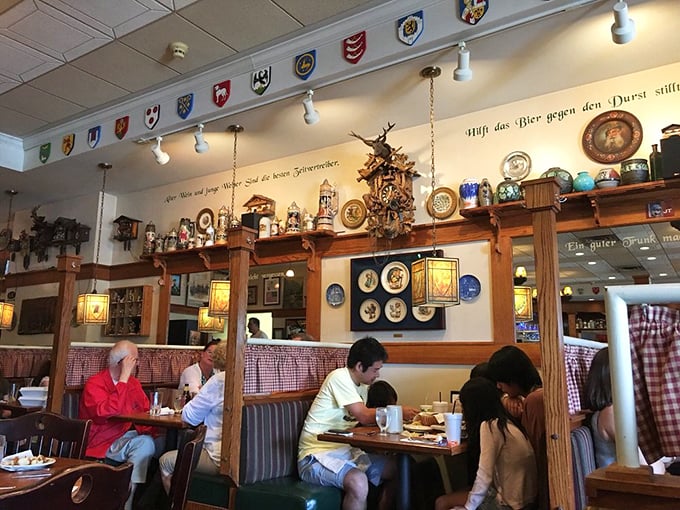Happy diners savoring their meals beneath a tapestry of German memorabilia. It's a scene straight out of a Bavarian postcard!