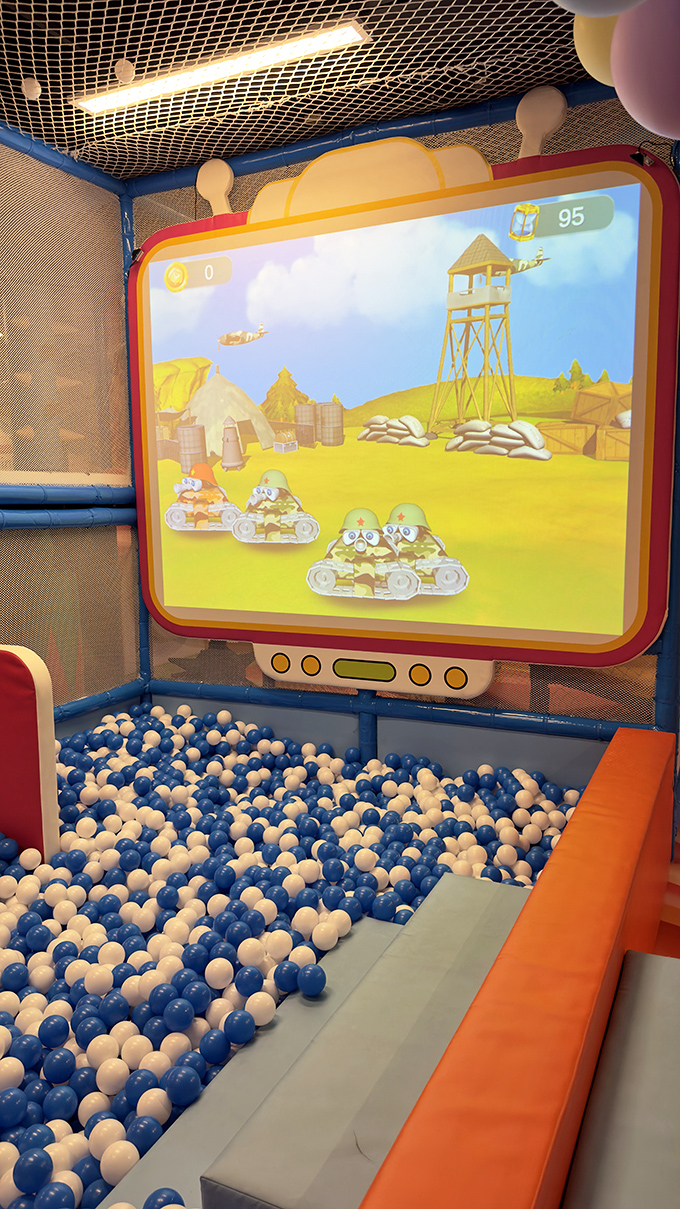 Game on! This sweet setup lets you play while surrounded by a sea of blue and white balls. It's like gaming inside a giant gumball machine!