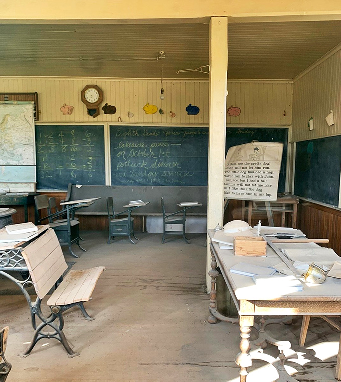 "Detention lasts forever in this classroom." Desks await phantom students, while the chalkboard holds lessons from a bygone era.