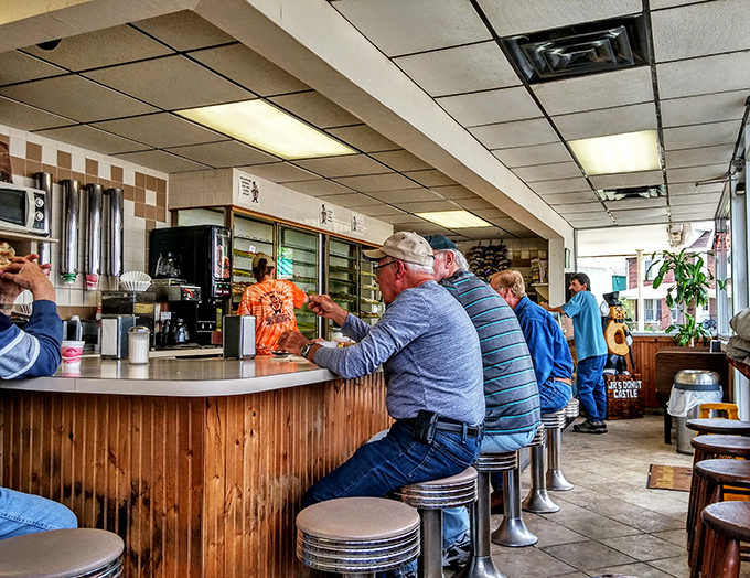 The breakfast club in session! Local regulars gather at the counter, solving the world's problems one donut at a time.