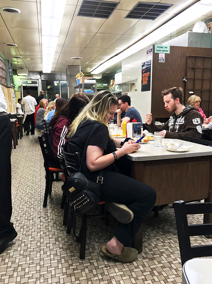 A late-night feast in progress. These diners aren't just eating, they're participating in a time-honored Detroit tradition.