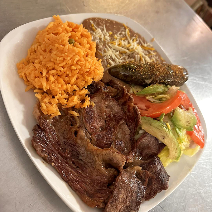 A plate that screams "fiesta"! This carne asada, with its colorful rice and beans, is like a south-of-the-border vacation for your palate.
