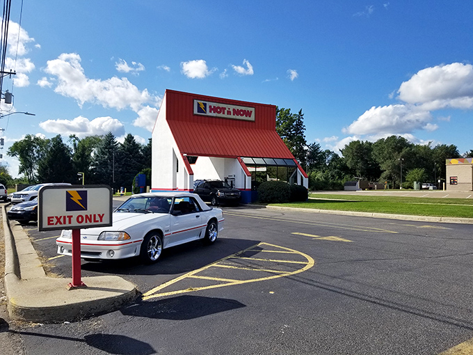 Red, white, and delicious! Hot 'n Now stands proud against the Michigan sky, a tasty testament to the American dream (and appetite).