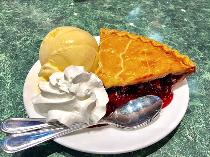 A slice of Americana, served &agrave; la mode. This fruit pie, with its flaky crust and generous scoop of ice cream, is like a warm hug for your taste buds.