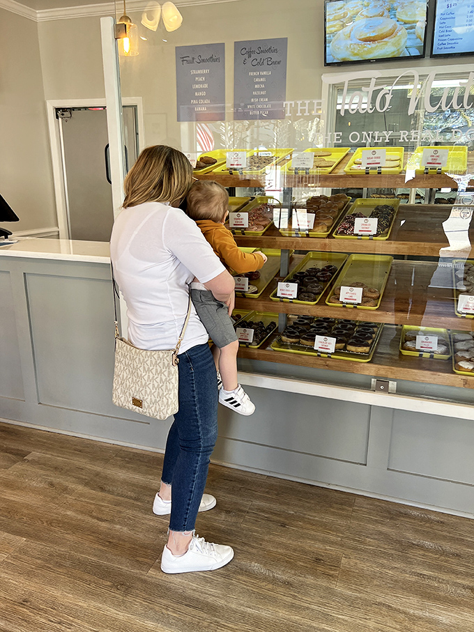 Choices, choices! Watching a customer pick their donut is like witnessing a kid in a candy store. The struggle is real.