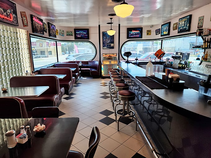 Diner design perfection! With its checkerboard floor and cozy booths, this space is a '50s fever dream come true.