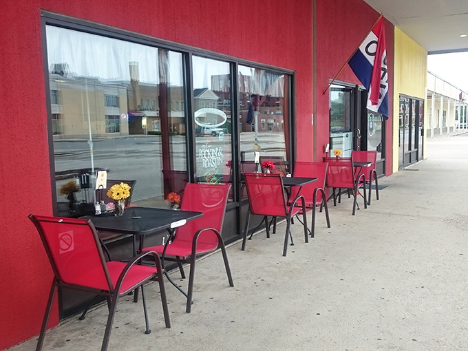 Outdoor seating that says, "Come for the food, stay for the people-watching." Red chairs ready for your culinary adventure.