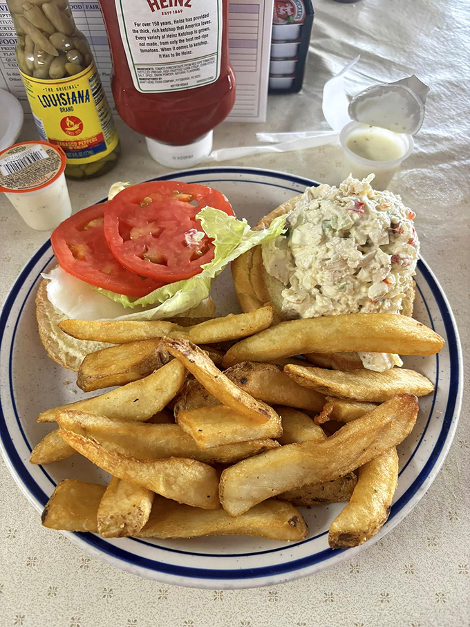 A sandwich that hugs you back! This chicken salad creation is comfort food at its finest, nestled between bread and surrounded by crispy fries.