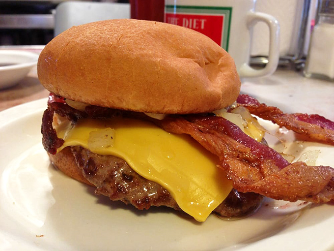 Meet the Nate's Burger: a towering testament to the art of excess. This isn't just a meal; it's a delicious Jenga tower of beef, cheese, and bacon.